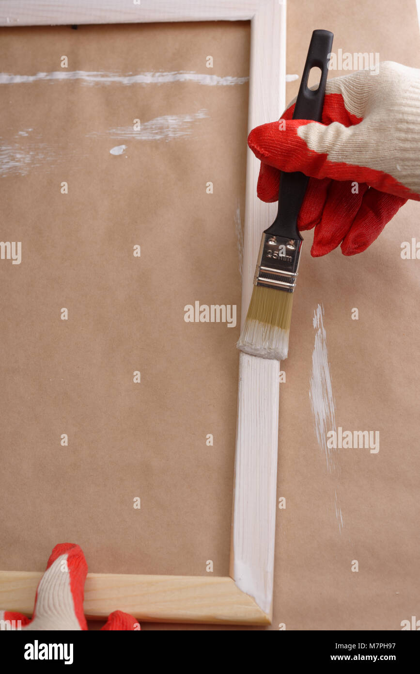 Painting a wooden frame in white color Stock Photo - Alamy