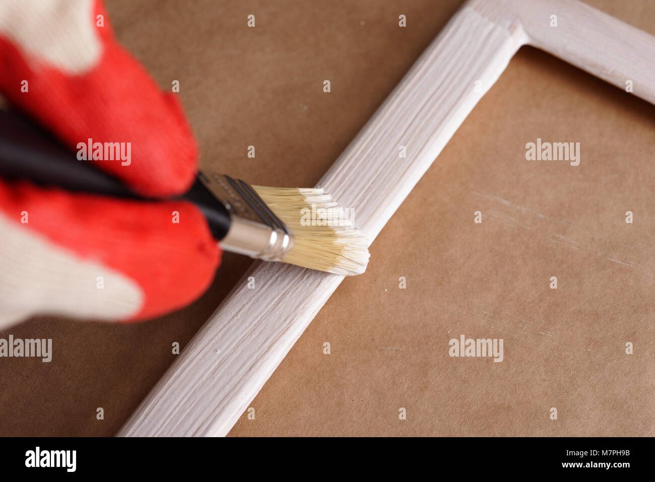 Painting a wooden frame in white color Stock Photo - Alamy