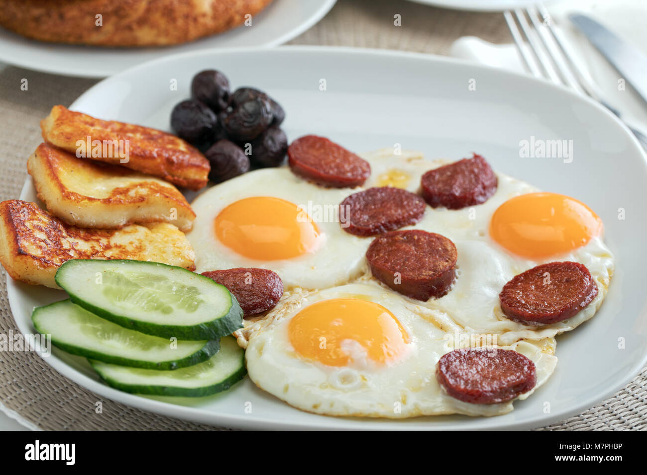 Turkish breakfast with fried egg, sucuk, halloumi cheese, vegetables ...