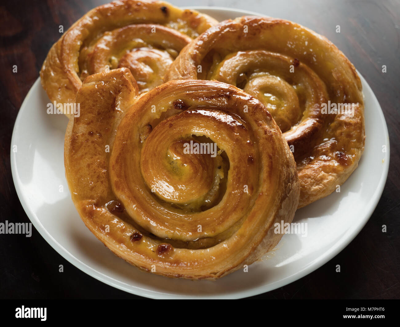 Close up of French raisin pastries on a white plate and wooden table ...