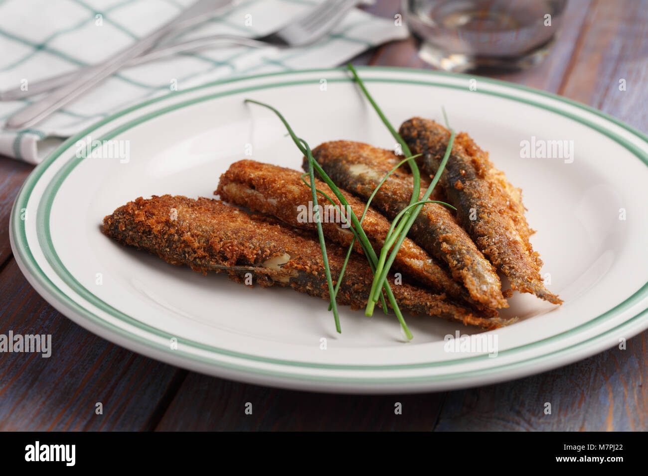 Roasted vendace fish on a rustic plate with green onion Stock Photo - Alamy