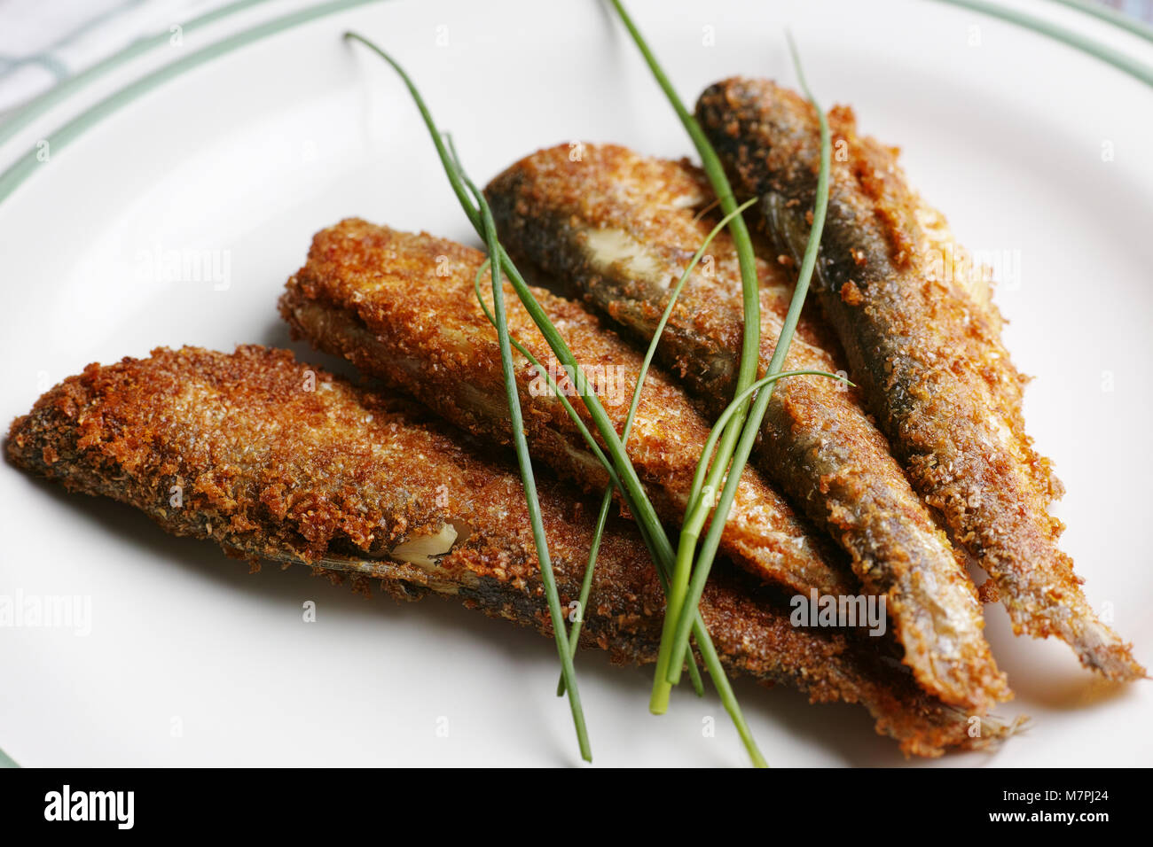Roasted vendace fish on a rustic plate with green onion Stock Photo - Alamy