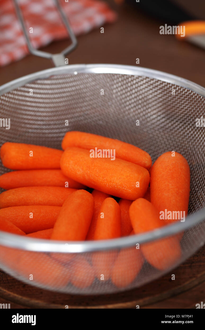 Pealed mini carrot in a strainer Stock Photo - Alamy