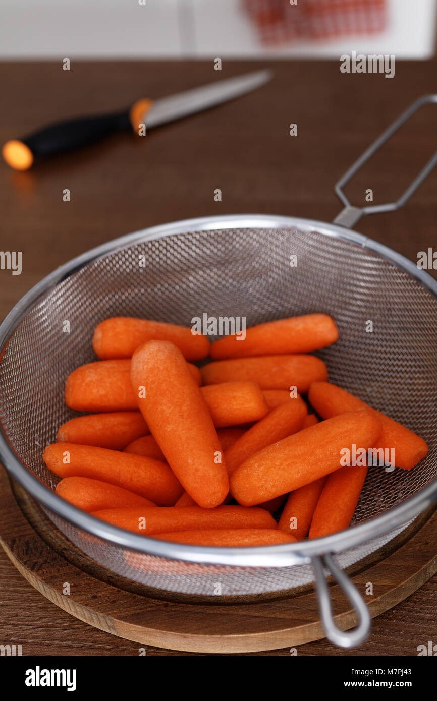 Pealed mini carrot in a strainer Stock Photo - Alamy