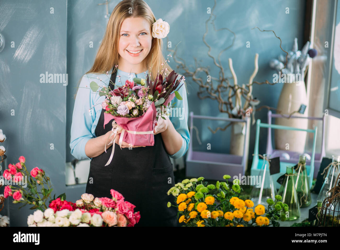 horizontal photo of smiling woman giving prepared flower composition to ...