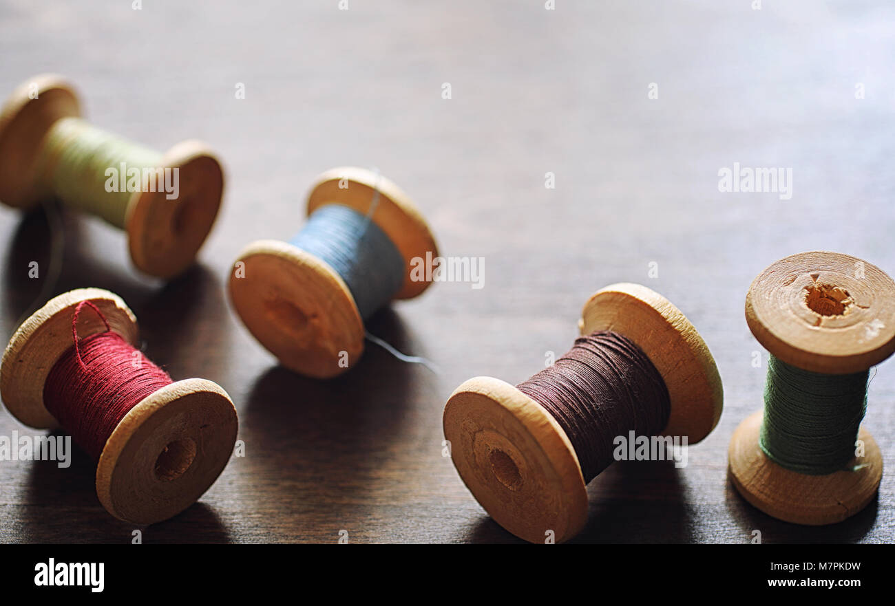 Sewing thread on a wooden background. Set of threads on bobbins Stock ...