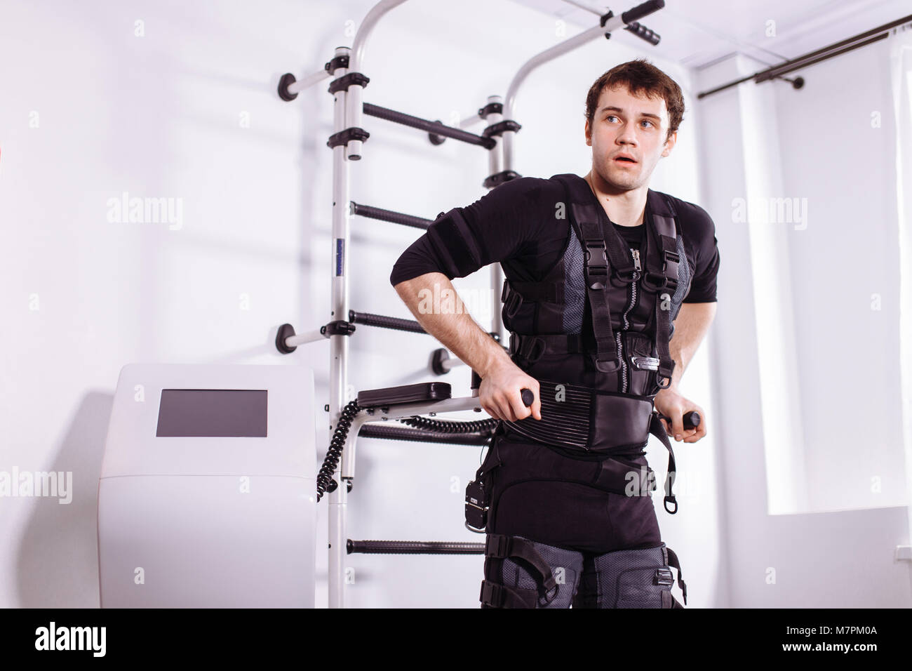 EMS male working out, doing push ups. Fit man doing triceps dips on ...