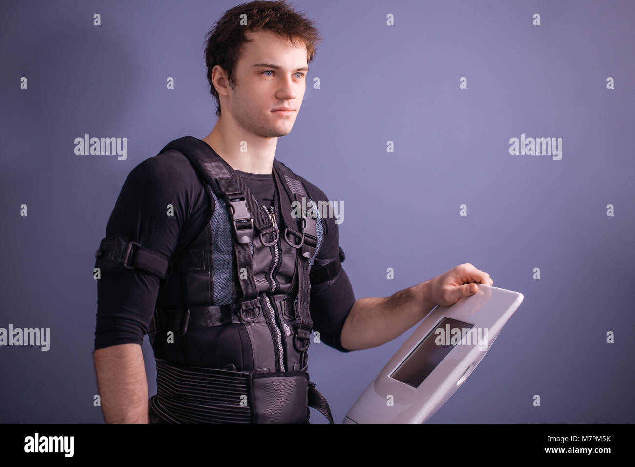 EMS, portrait of handsome man near electro muscle stimulation machine ...