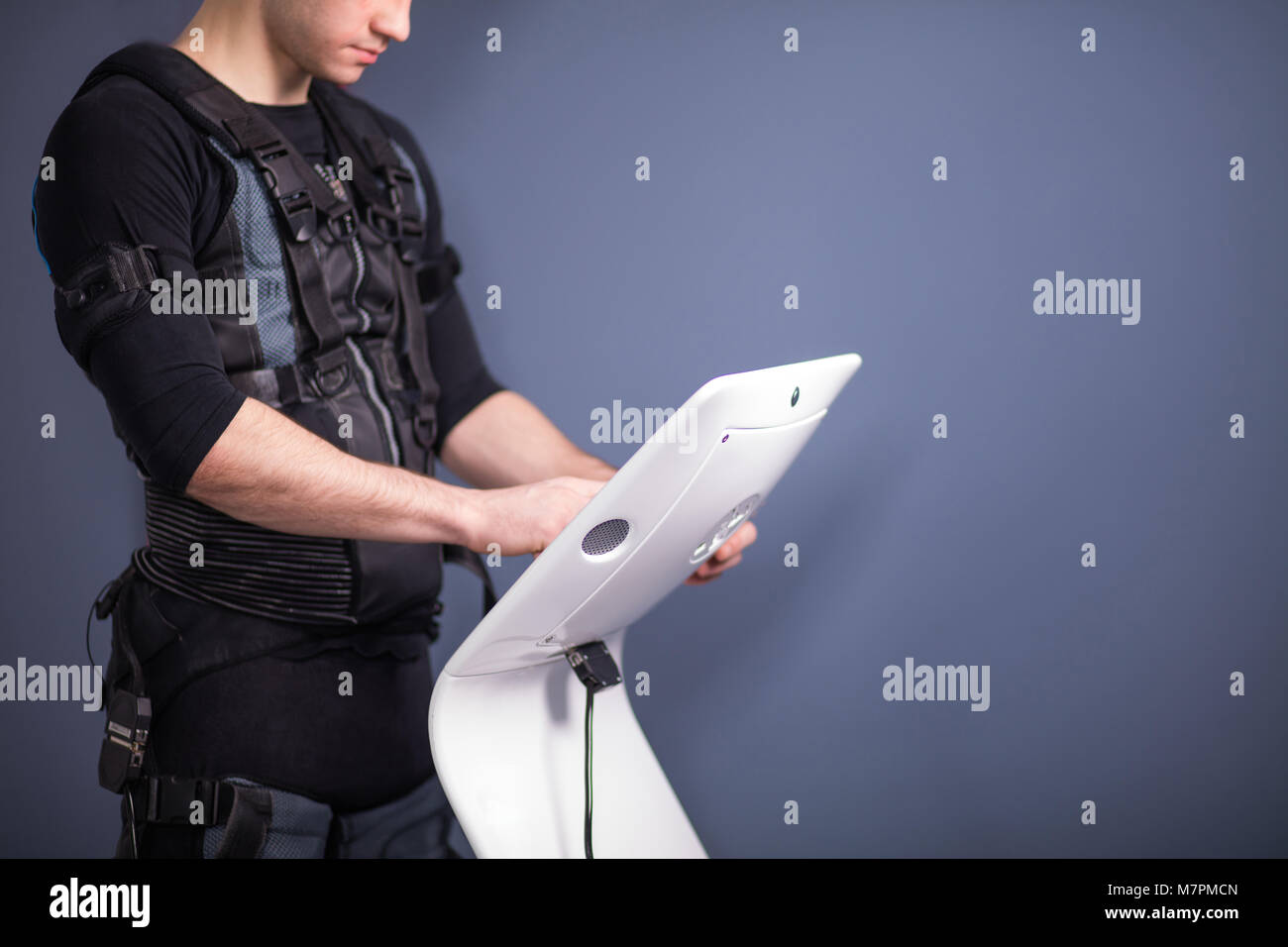 Male athlete select intensity of ems electro muscular stimulation ...