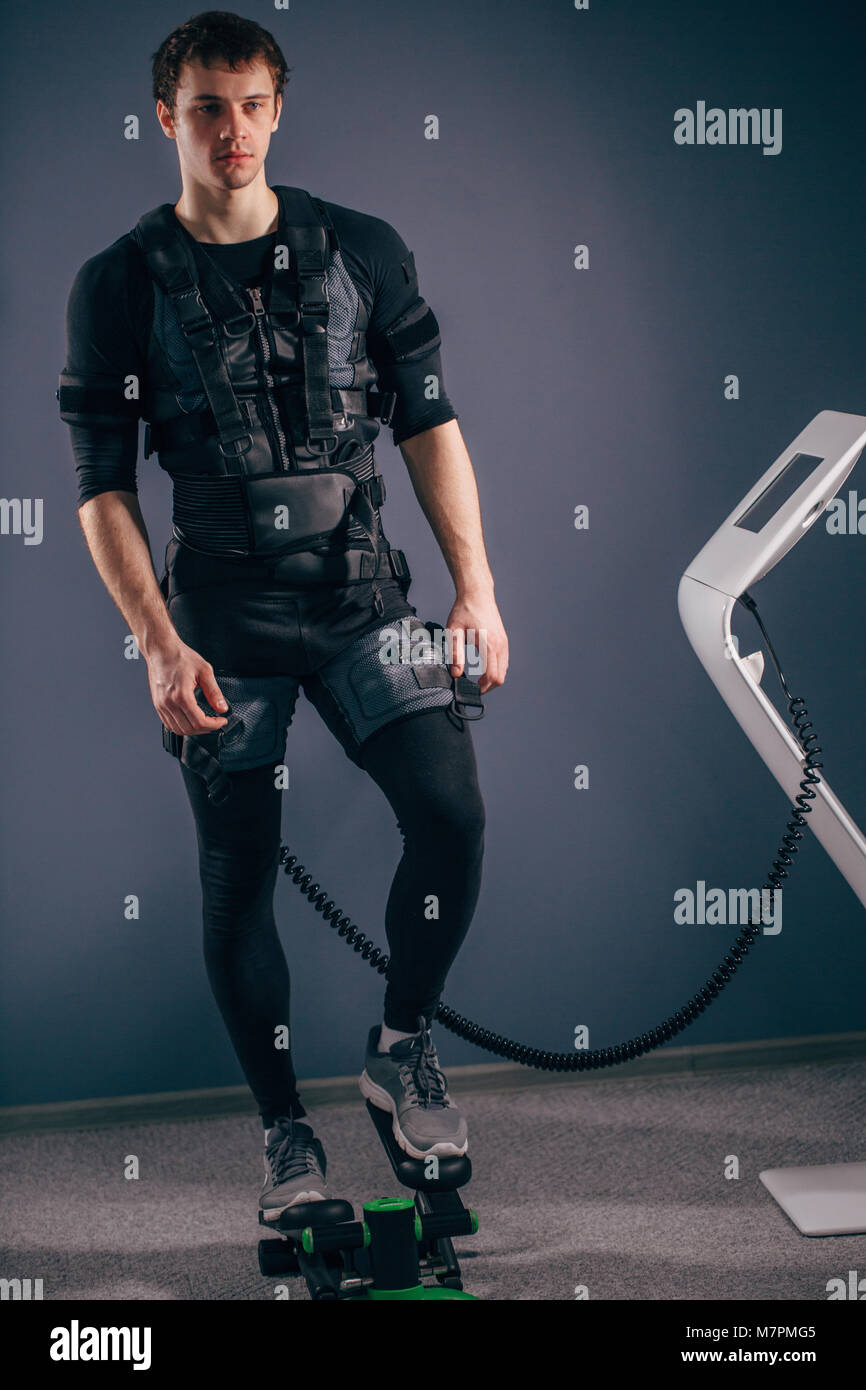 Caucasian man wearing biometric fitness vest training on stepper with ...