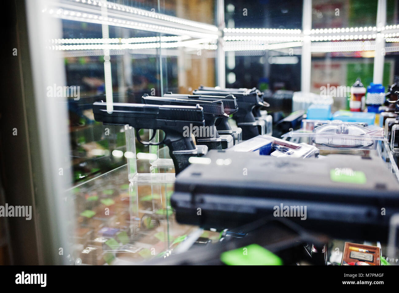 Different guns and revolvers on shelves store weapons on shop center ...