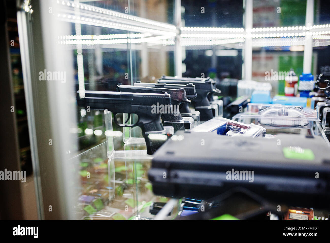 Different guns and revolvers on shelves store weapons on shop center ...