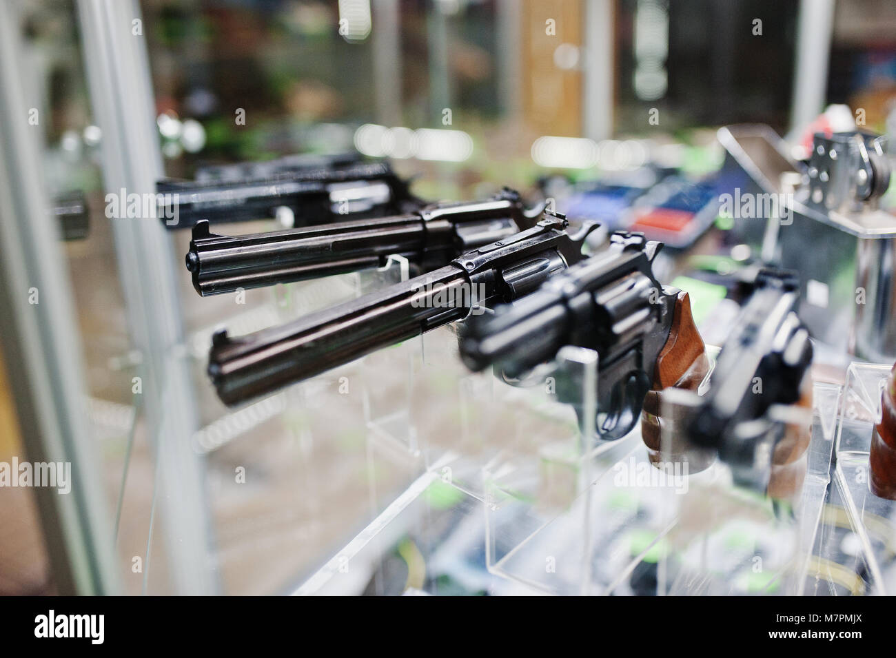Different guns and revolvers on shelves store weapons on shop center ...