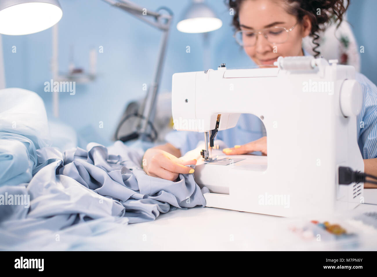 cropped shot of woman learning to sew on sewing machine in design ...