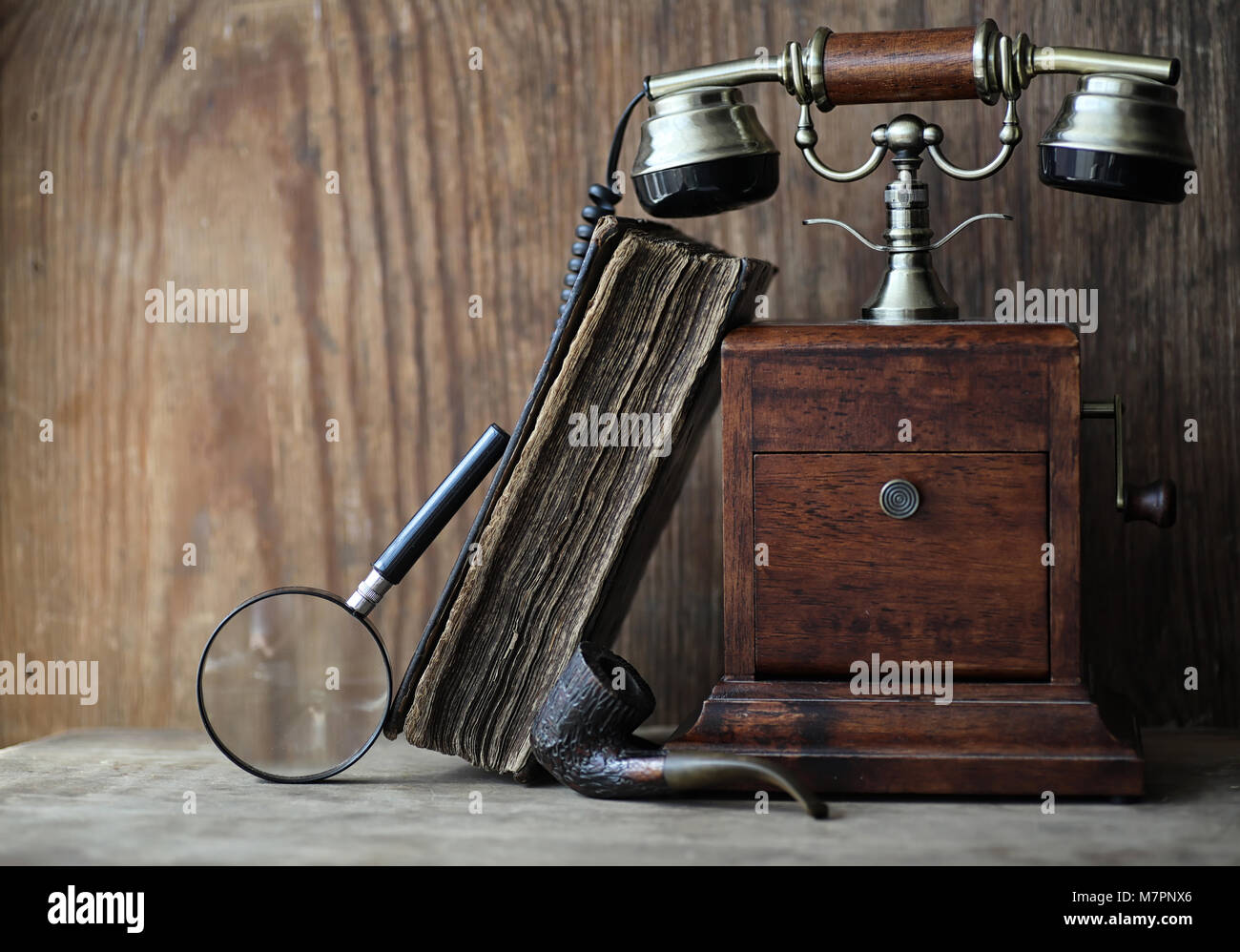 Old telephone and retro book on a wood Stock Photo - Alamy