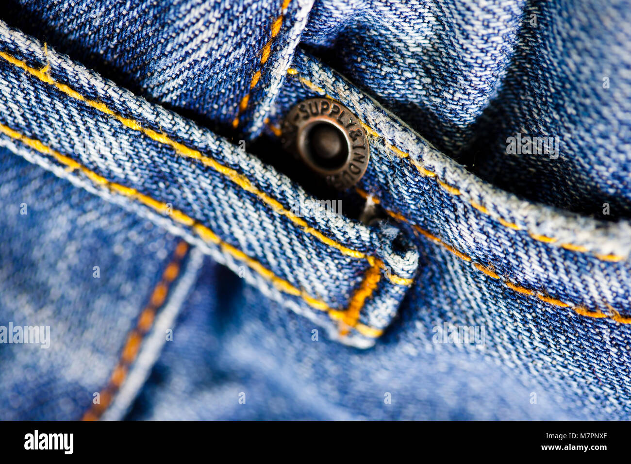 Macro shot of denim jeans showing stitching and metal stud Stock Photo ...