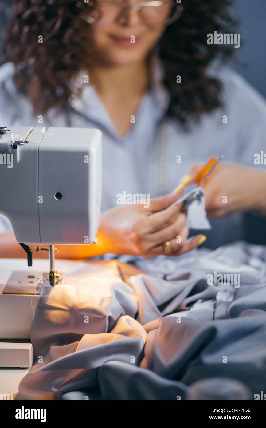 closeup cropped photo of cutting fabric with scissors. useful tool for ...