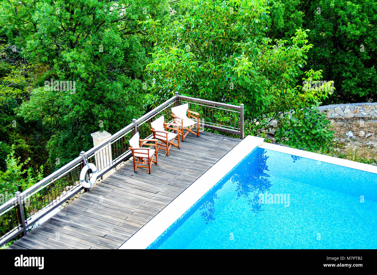 High angle view of swimming pool in natural green background. Greece ...