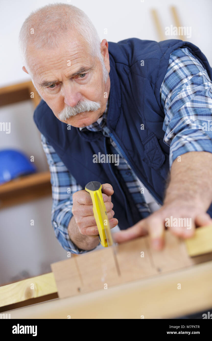 senior man sawing a log handsaw Stock Photo - Alamy