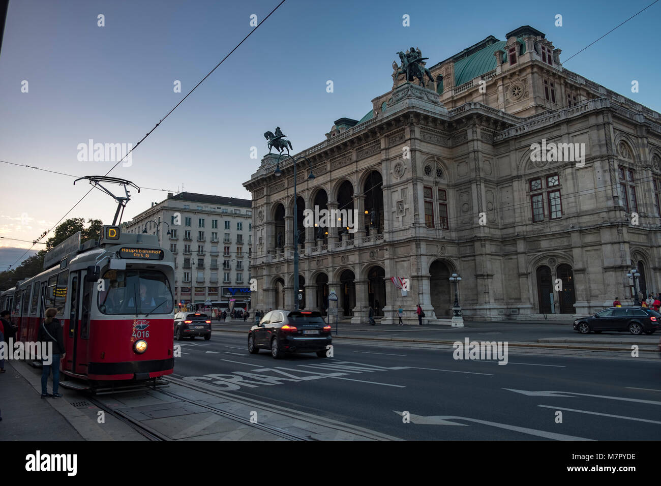 Old tram pulls away from stop with the Vienna Opera House Behind. Taken ...