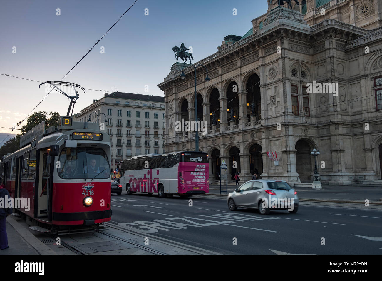 Old tram pulls away from stop with the Vienna Opera House Behind. Taken ...