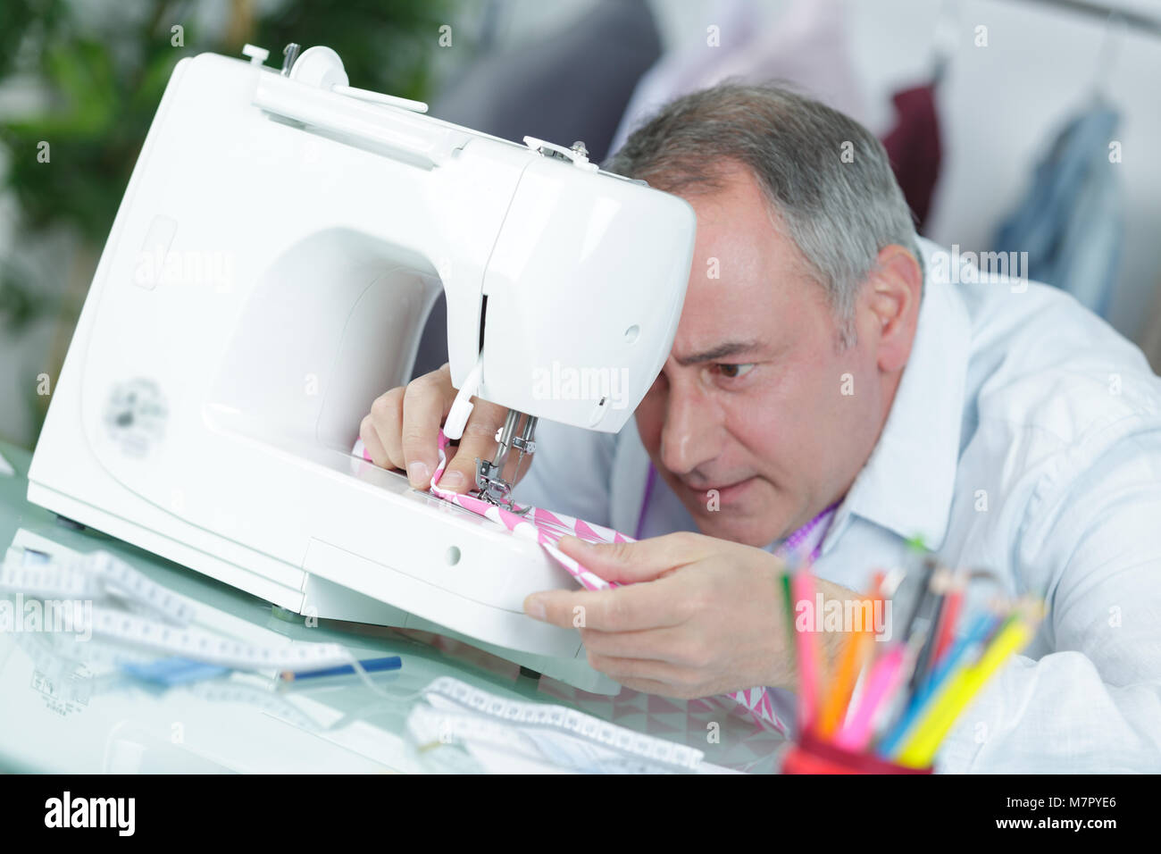 middle-age fashion designer sewing with a sewing machine Stock Photo ...