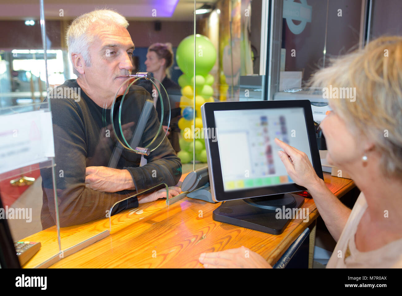 Man buying ticket at booth Stock Photo - Alamy