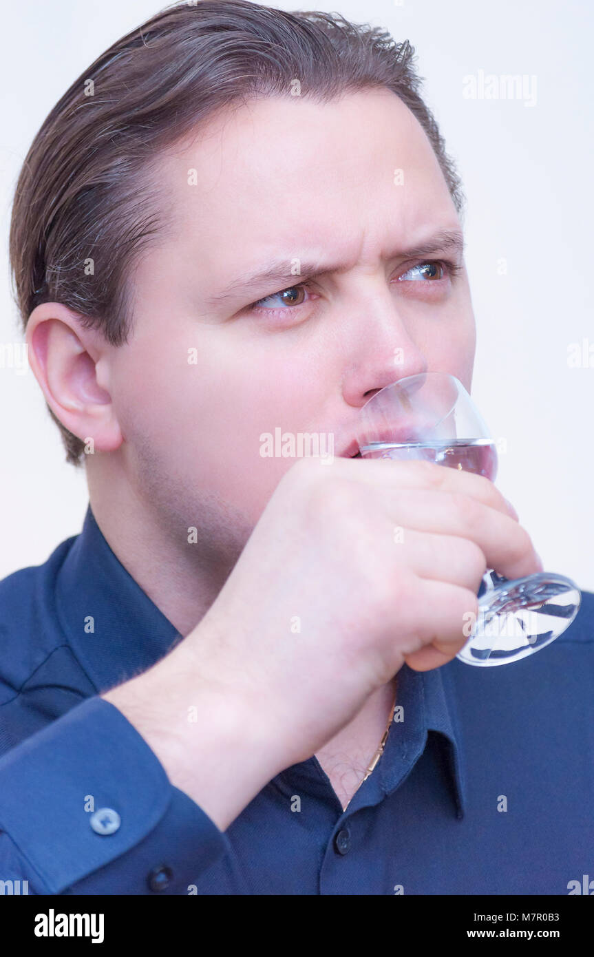 Portrait of young Caucasian Ethnicity man with blue shirt drinking ...