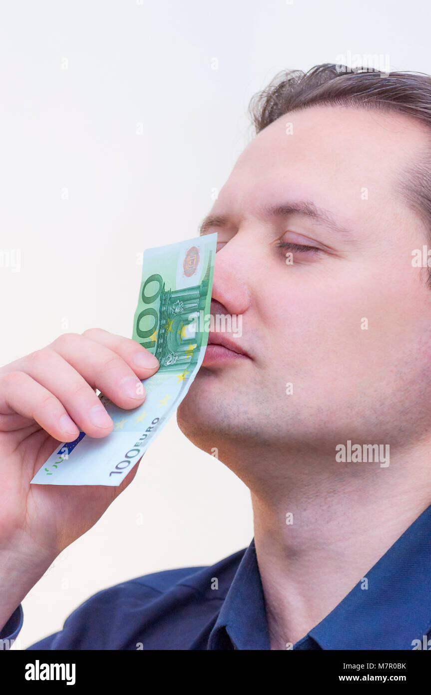 Portrait of young Caucasian Ethnicity man smelling money one hundred ...