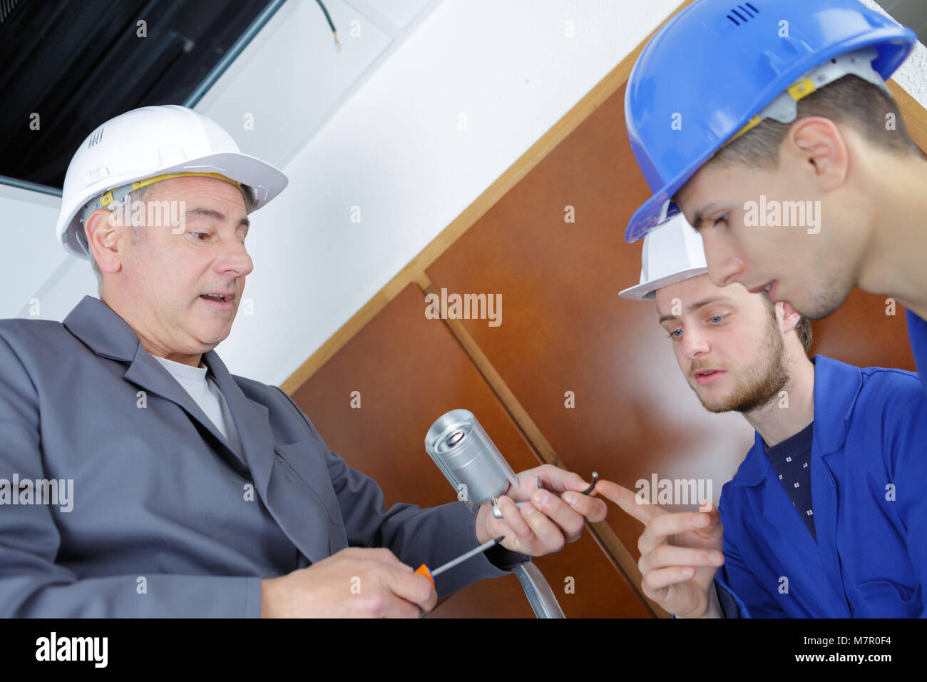 teacher helping college students studying plumbing Stock Photo - Alamy