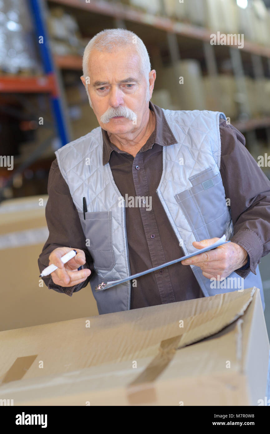 senior worker checking carton in warehouse for shipping Stock Photo - Alamy
