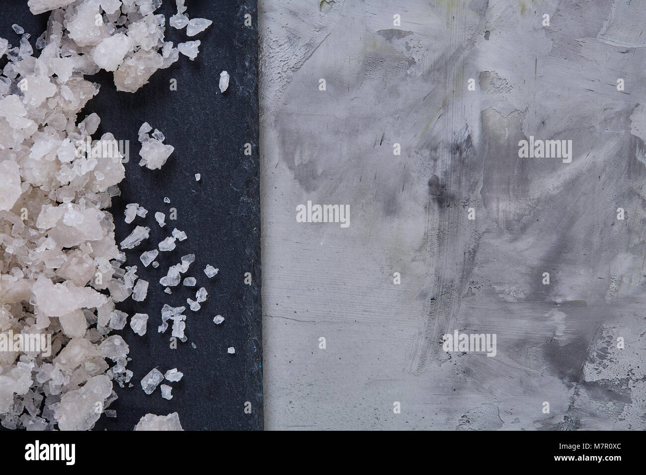 Pile of salt crystals isolated on the dark board over white textured ...