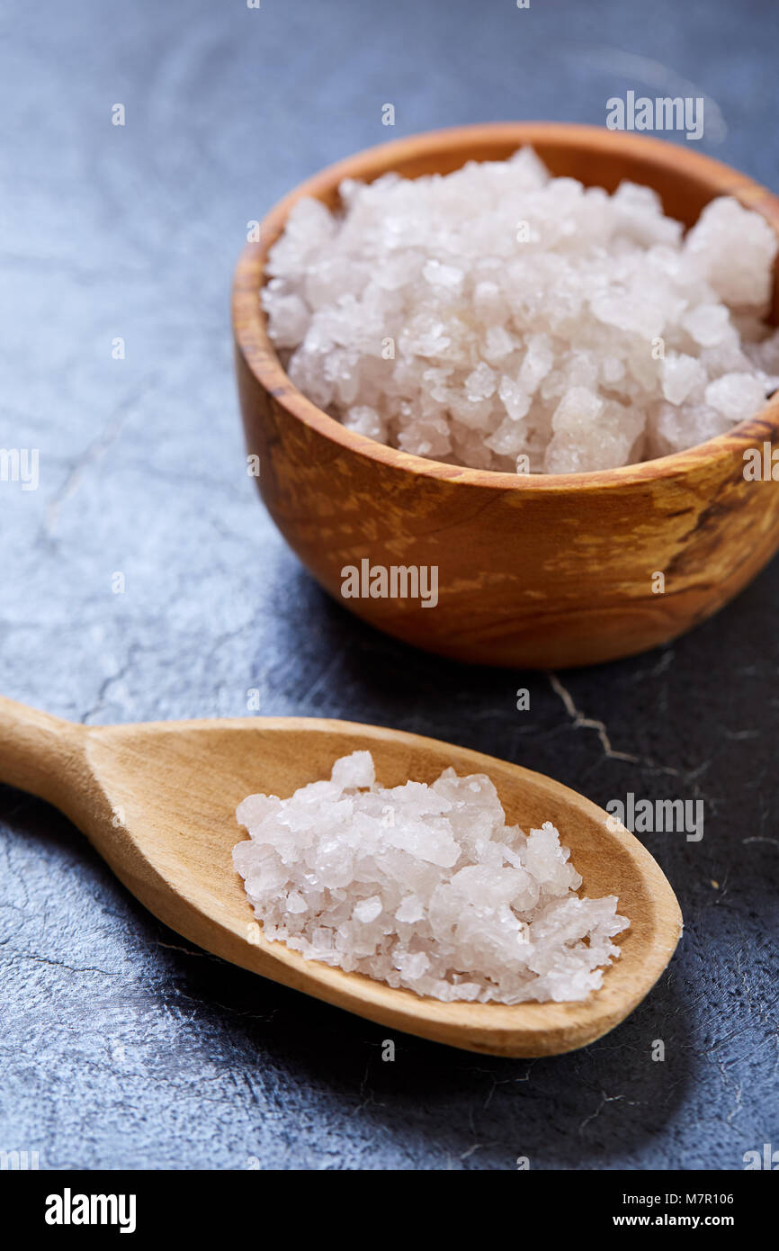 Large white sea salt crystals in a natural wooden bowl and wooden spoon ...