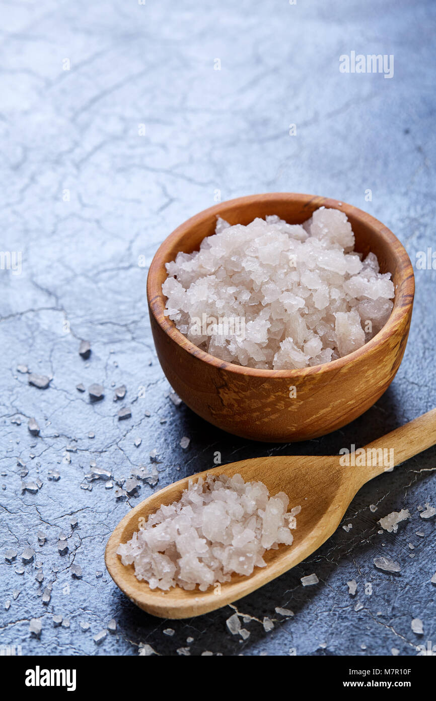Large white sea salt crystals in a natural wooden bowl and wooden spoon ...