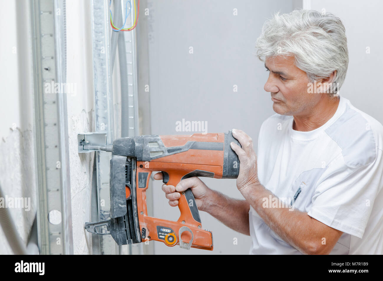 Worker using a nail gun Stock Photo - Alamy