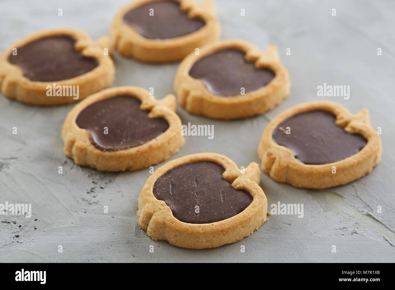 Sweet apple shaped cookies arranged in rows on light textured ...