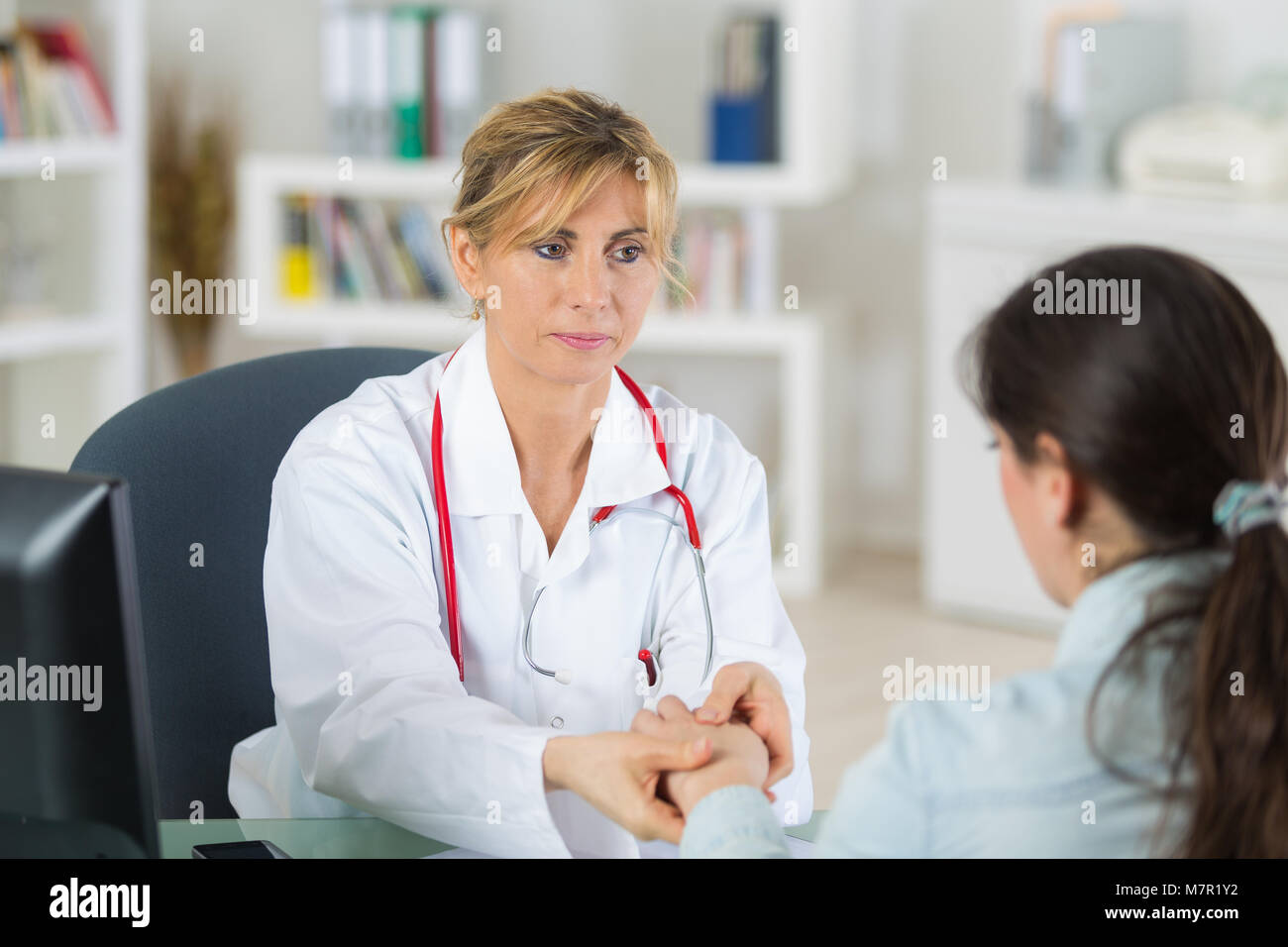 beautiful female doctor holding her patients hand Stock Photo - Alamy