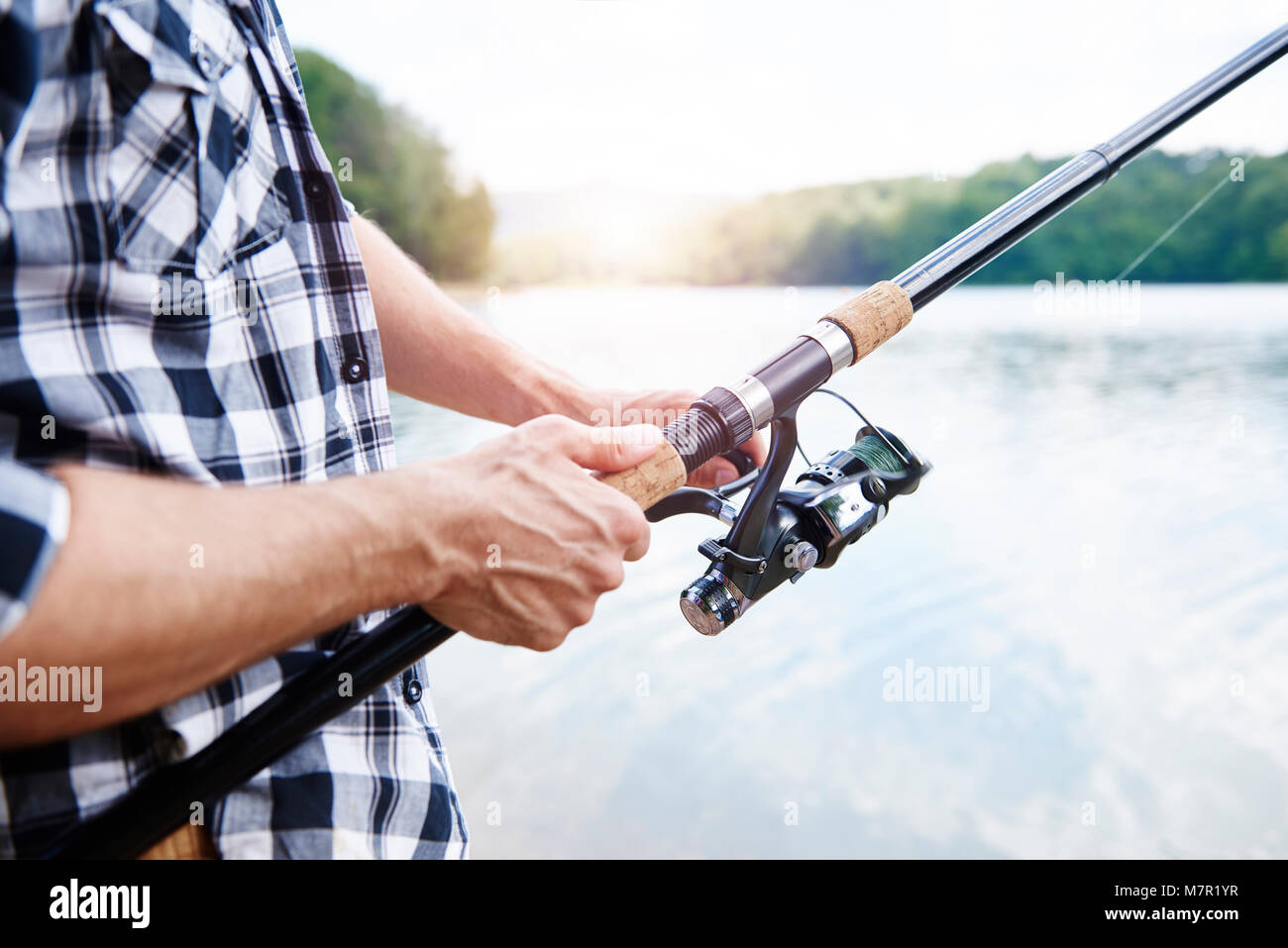 Human hand holding fishing rod Stock Photo - Alamy