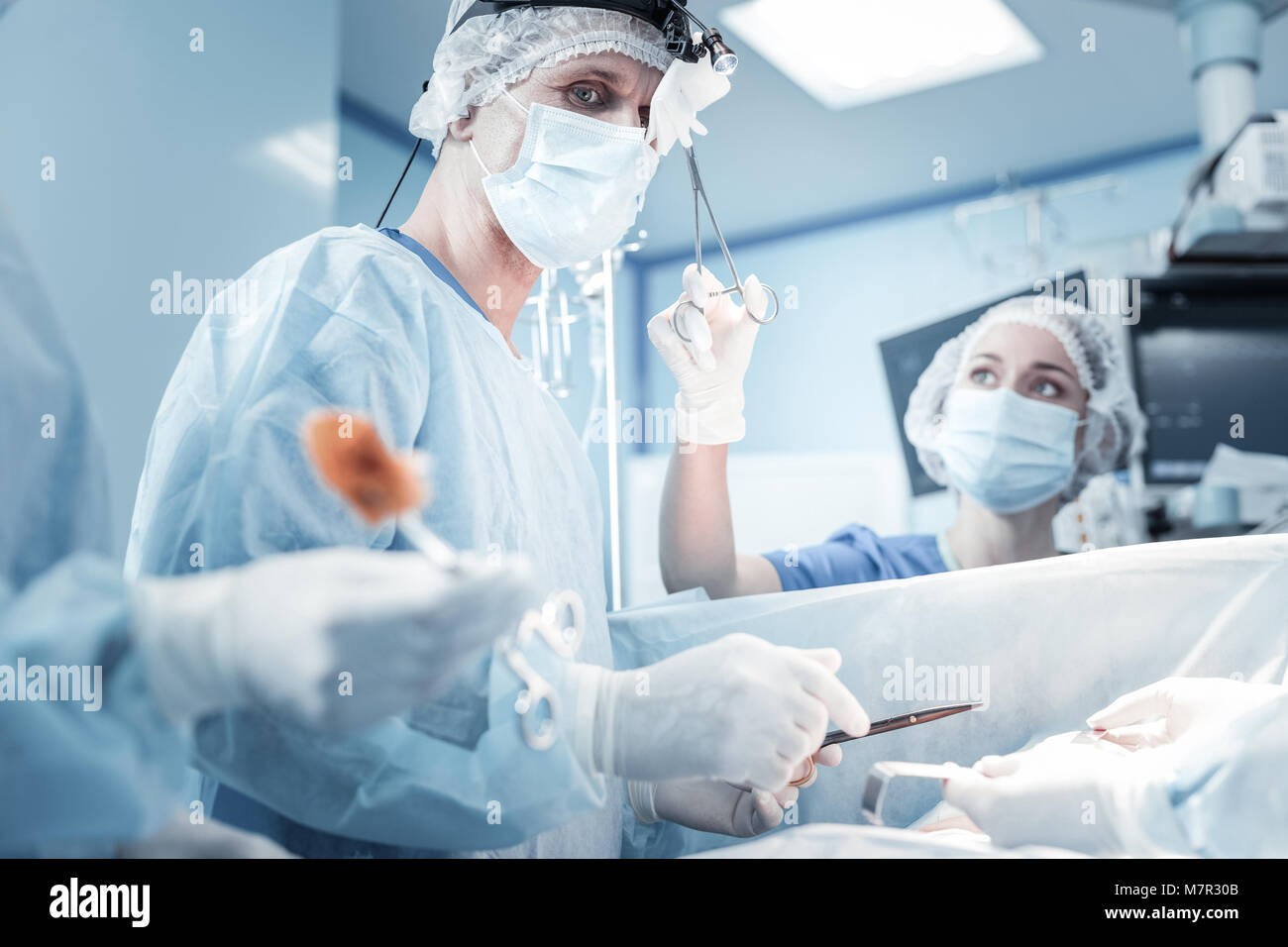 Concentrated qualified surge doing the operation looking at a clamp ...