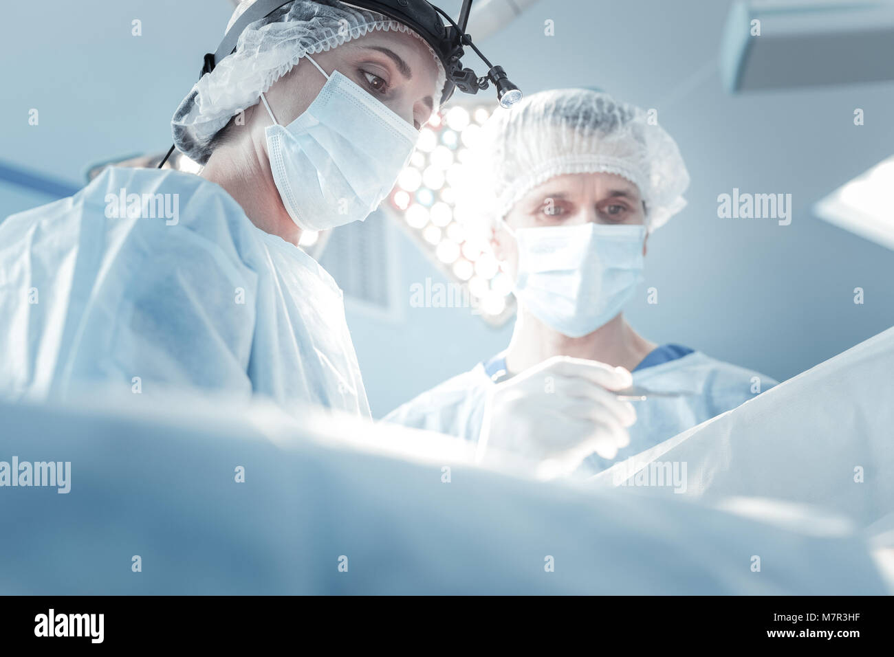 Serious qualified doctors looking down and doing theirs job Stock Photo ...