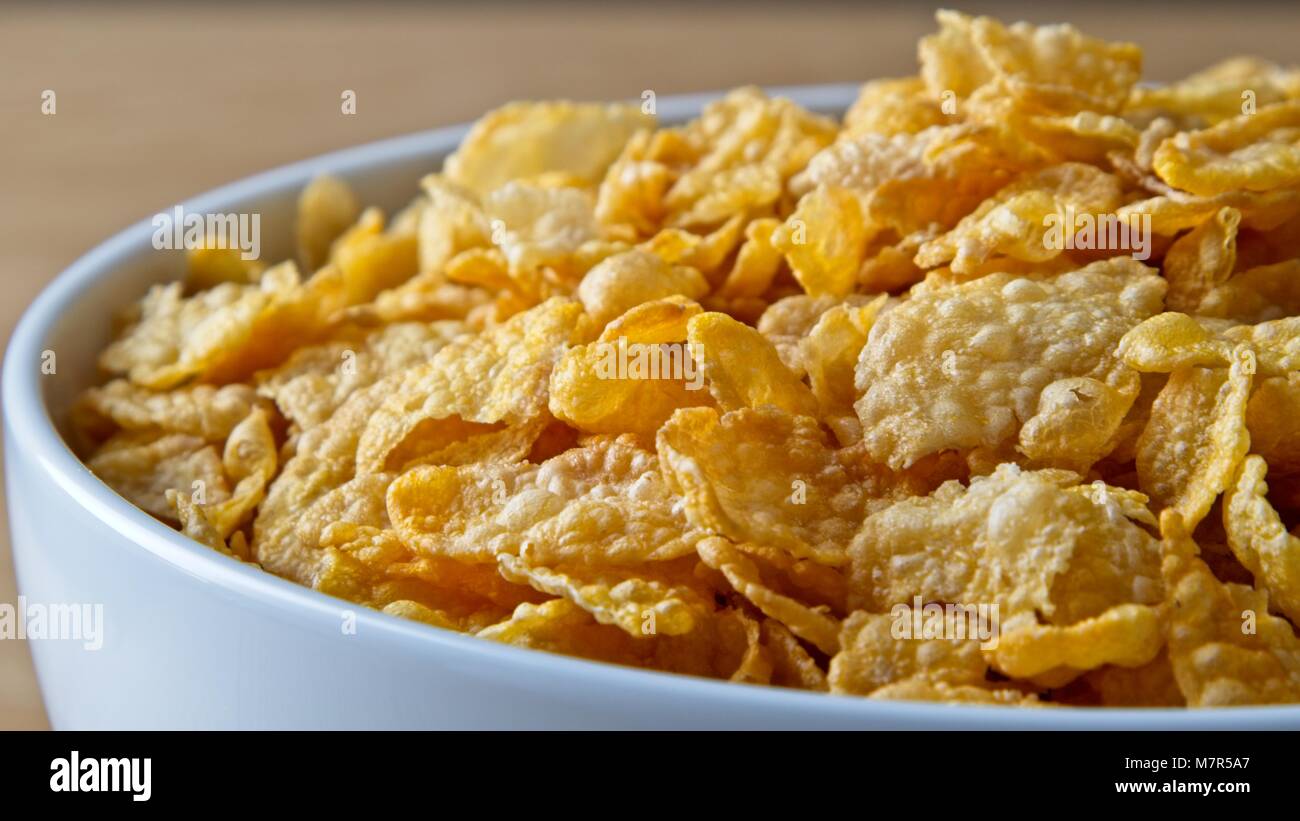 Bowl of corn flakes in white bowl on oak surface closeup Stock Photo ...