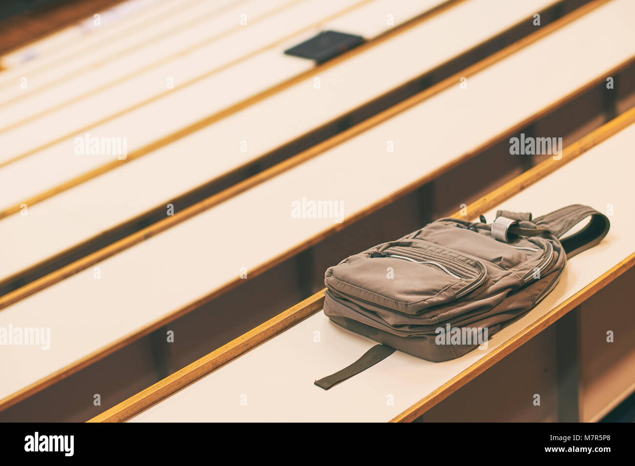 Student fabric backpack bag on the desk in university auditorium Stock ...