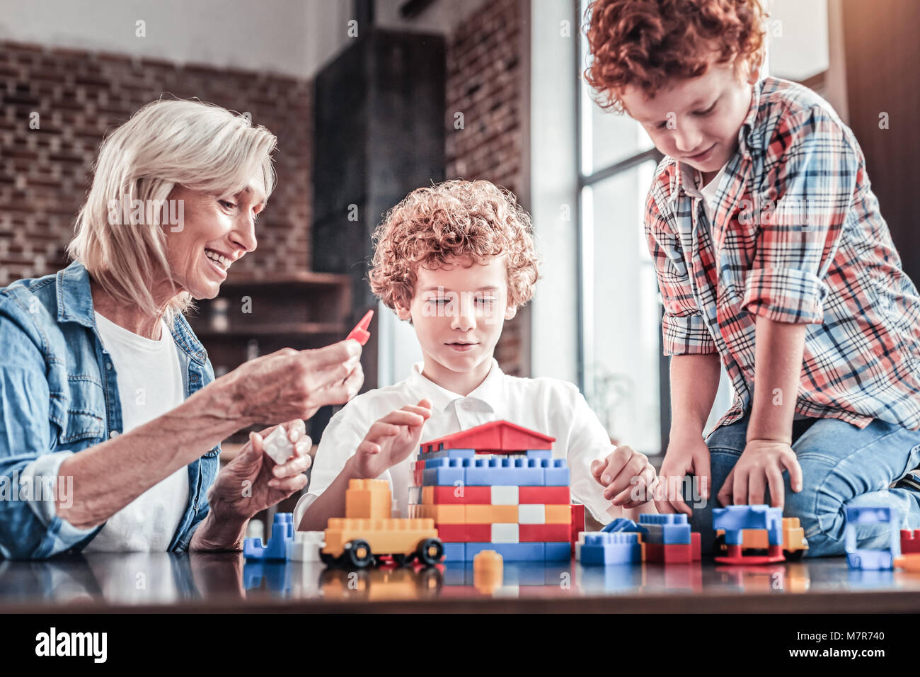 Happy positive family playing with the constructor set Stock Photo - Alamy