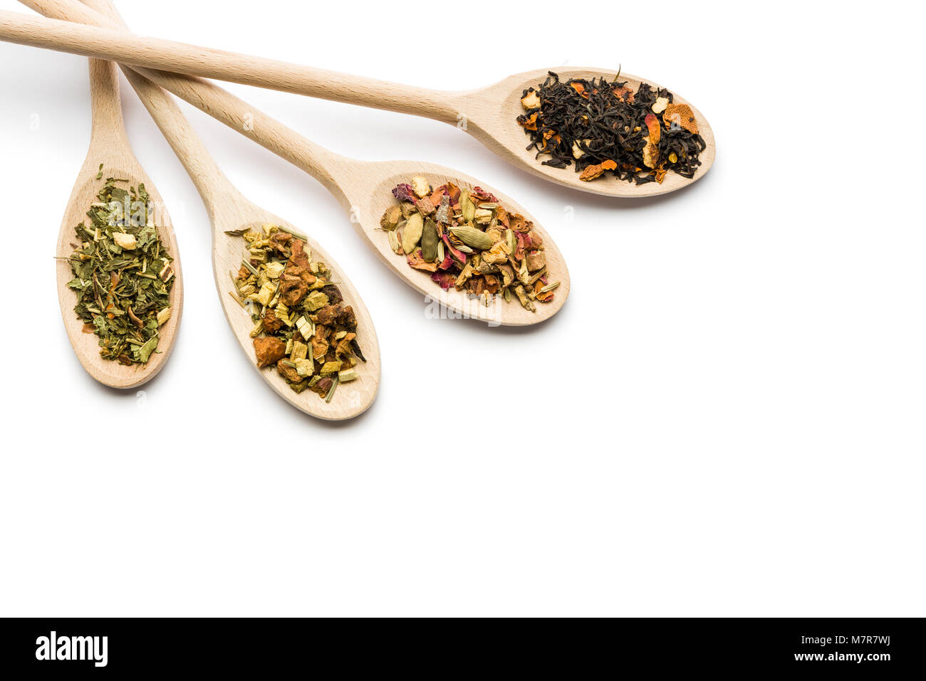 variety of tea blend on wooden spoon on white background with copy ...