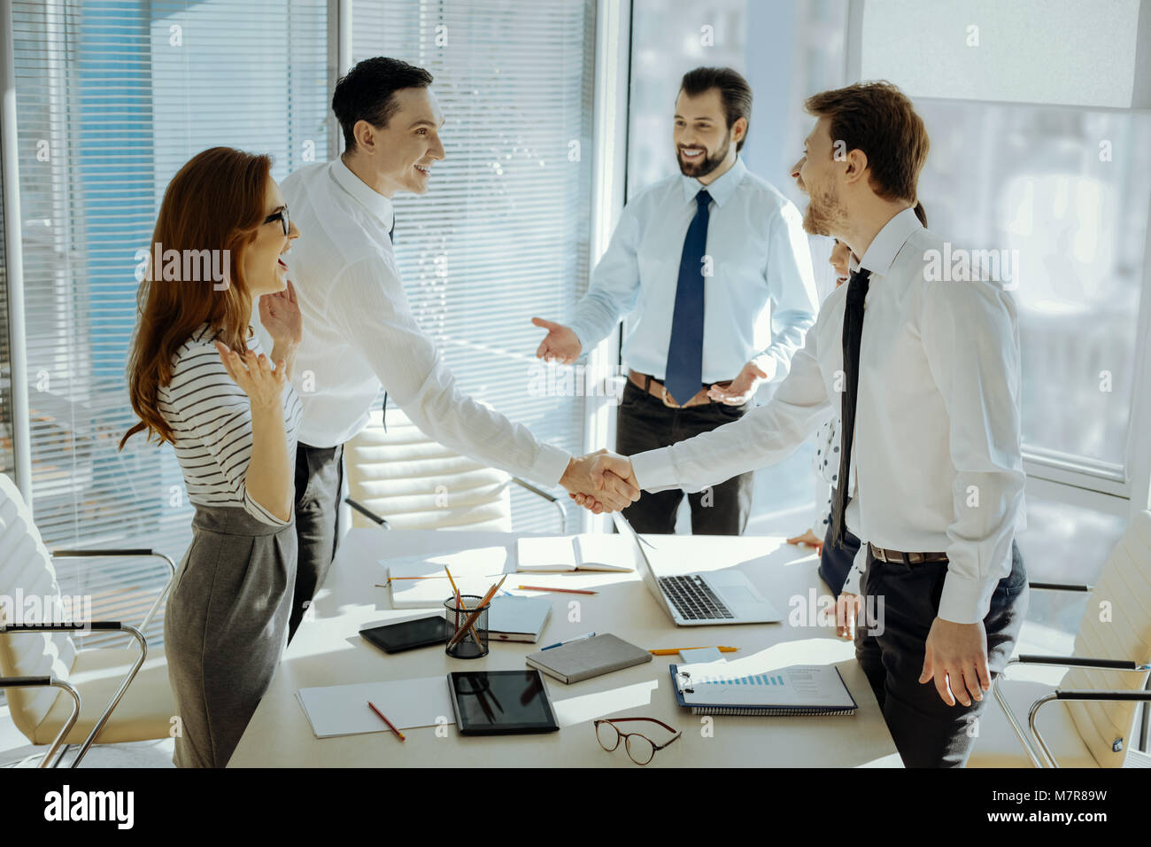 Cheerful businesspeople shaking hands with each other Stock Photo - Alamy