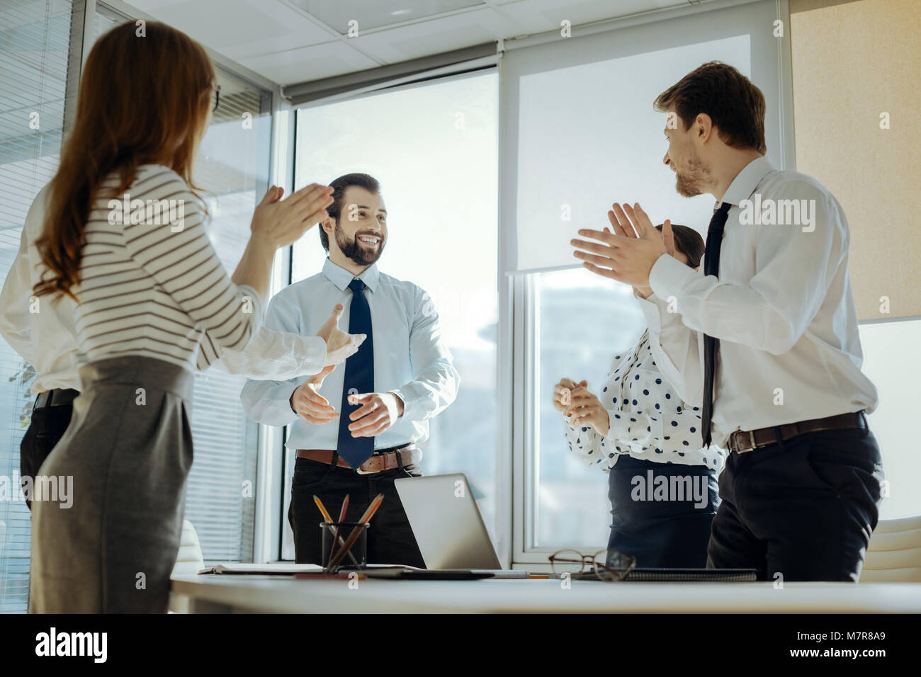 Joyful employees congratulating their colleague with promotion Stock ...