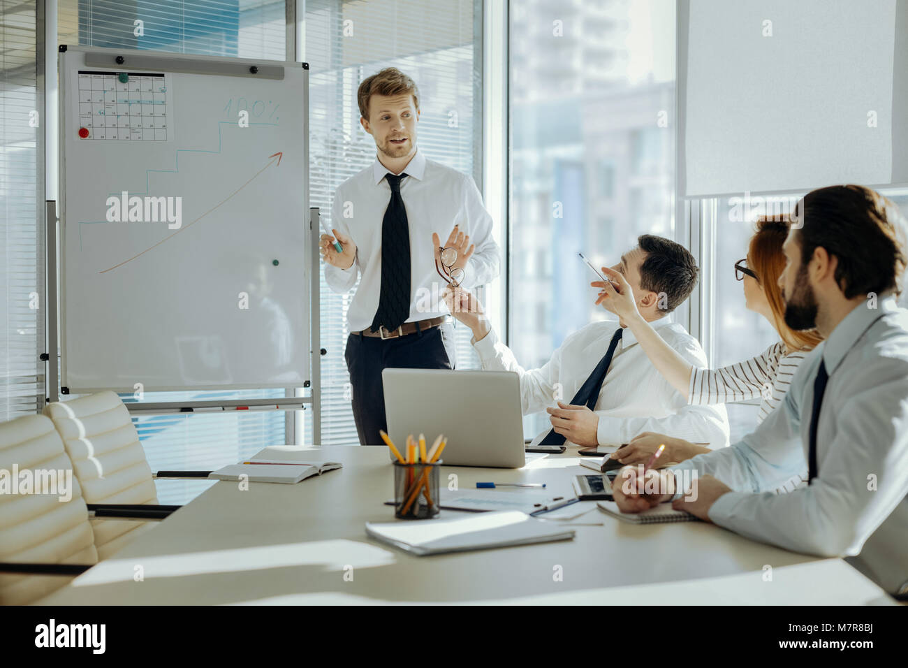 Cheerful boss explaining project objectives to his employees Stock ...