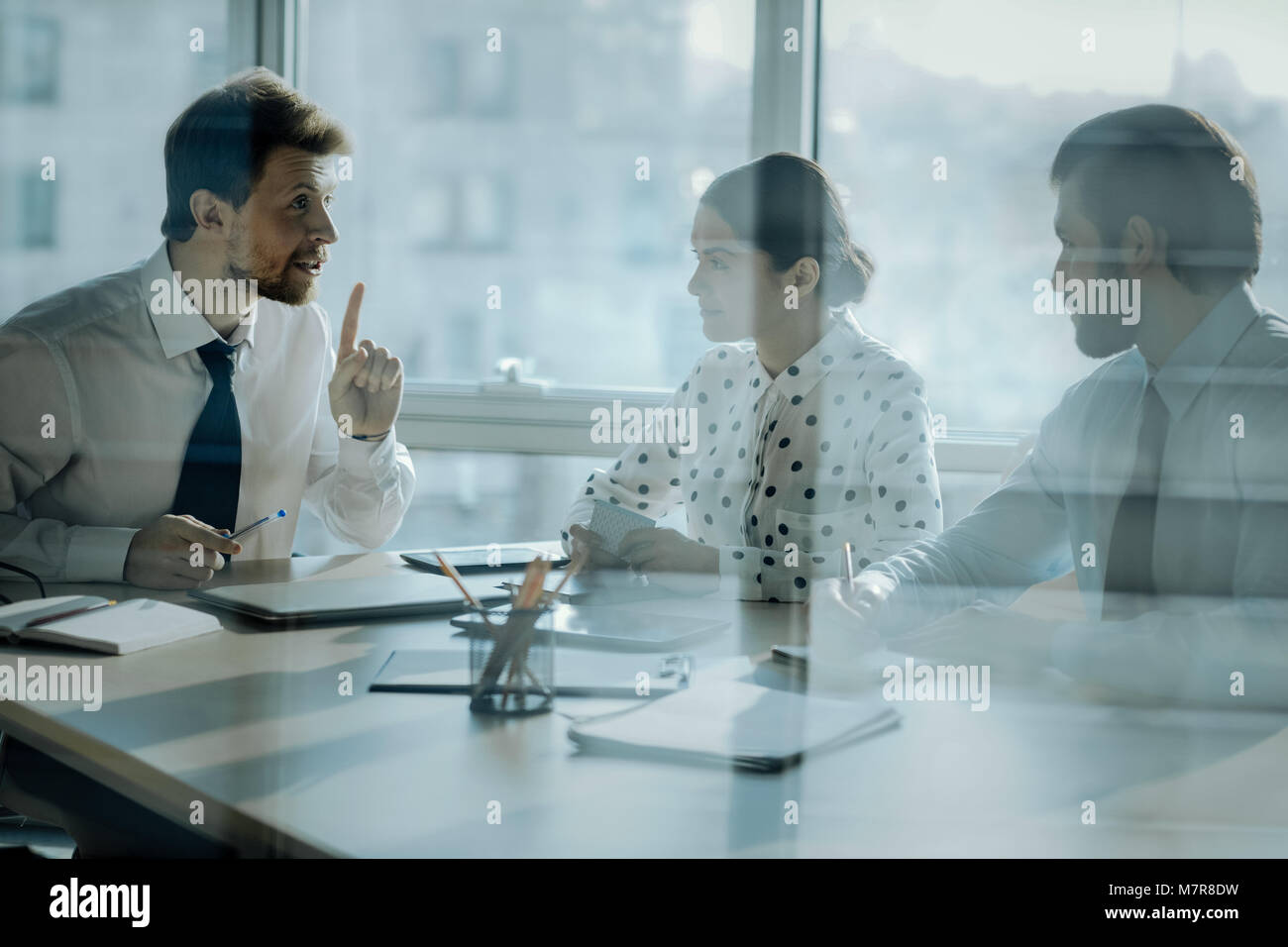 Two colleagues discussing work with boss in the office Stock Photo - Alamy