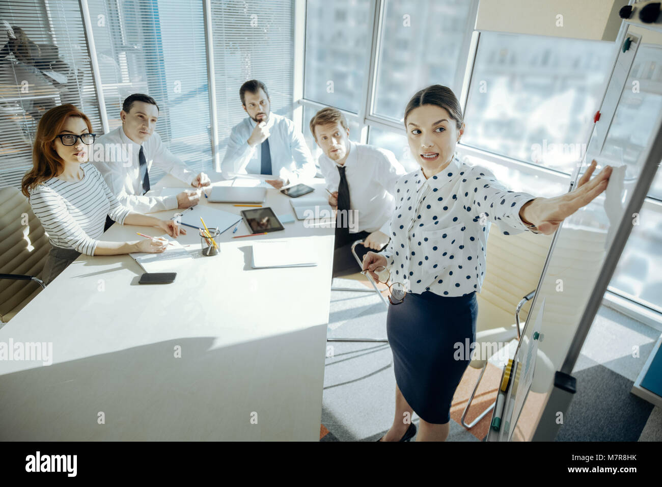 Pretty team leader telling her colleagues a new project plan Stock ...