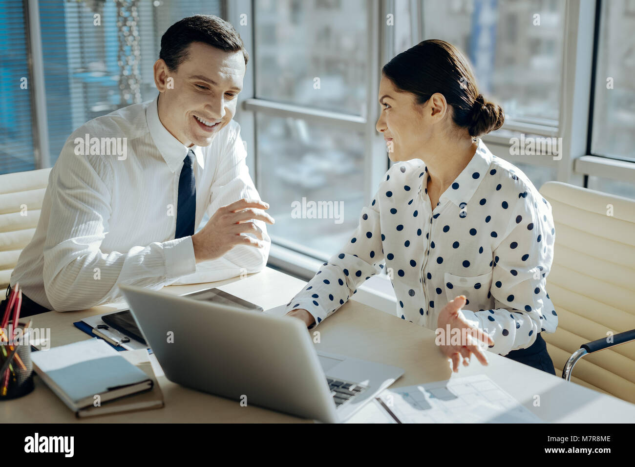 Charming female boss commenting on employees report Stock Photo - Alamy